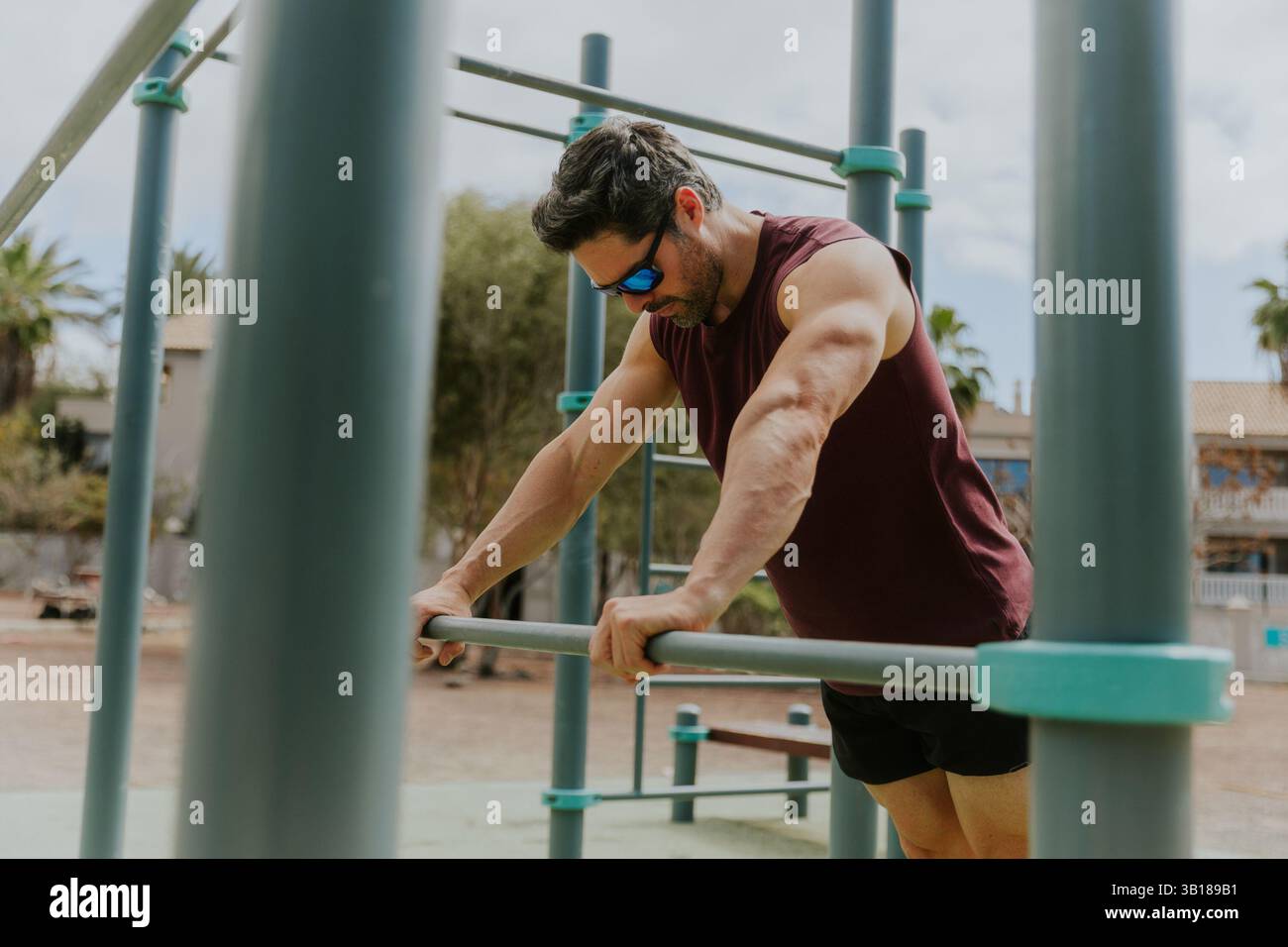Portrait of a man during an intense workout at a calisthenics outdoor ...