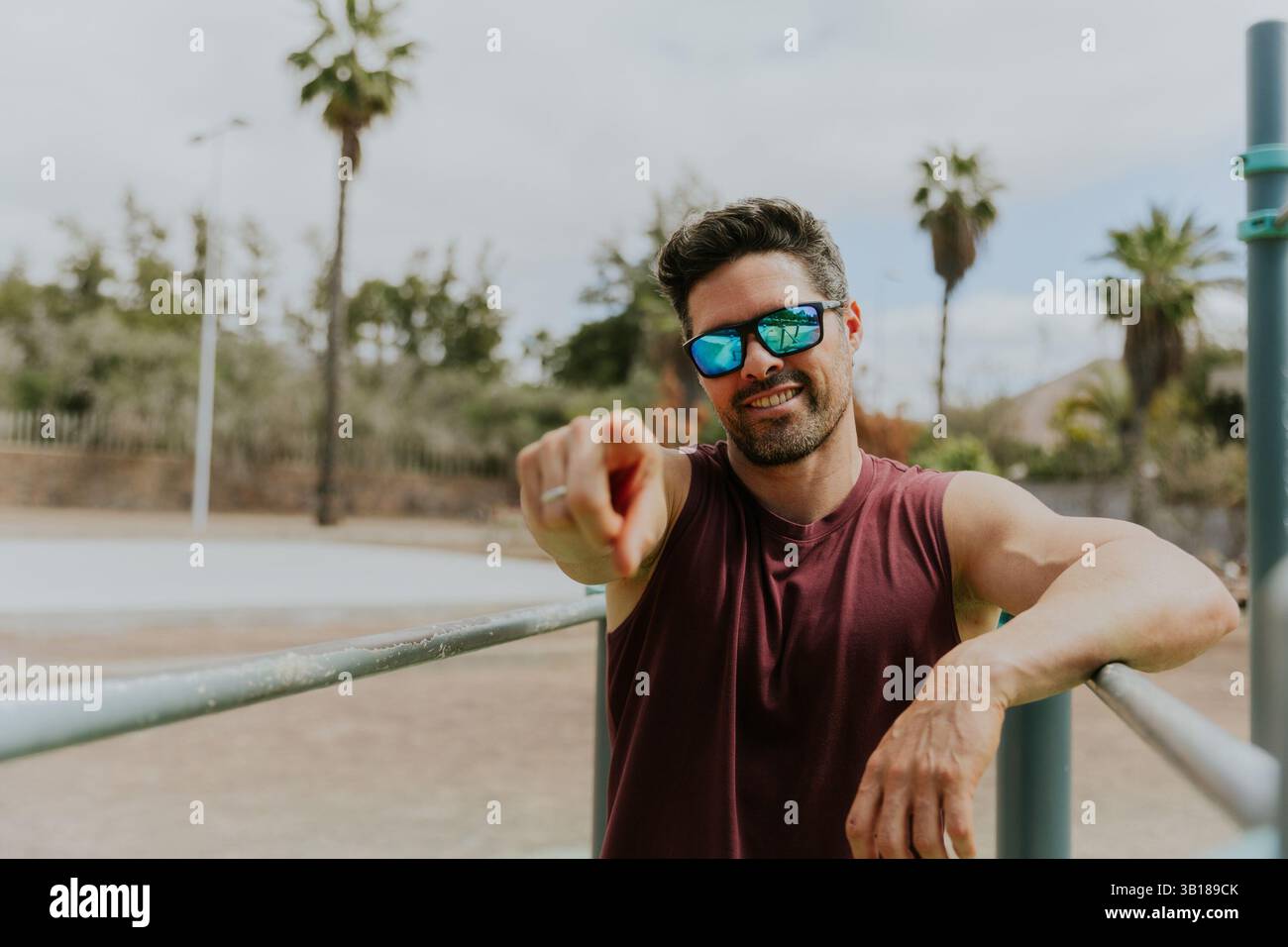 A fit 40 years old man points to the camera with his finger during a ...