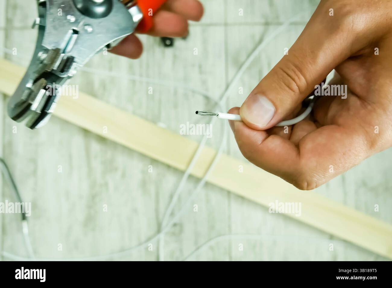 Stripping the ends of wires and connecting them Stock Photo - Alamy