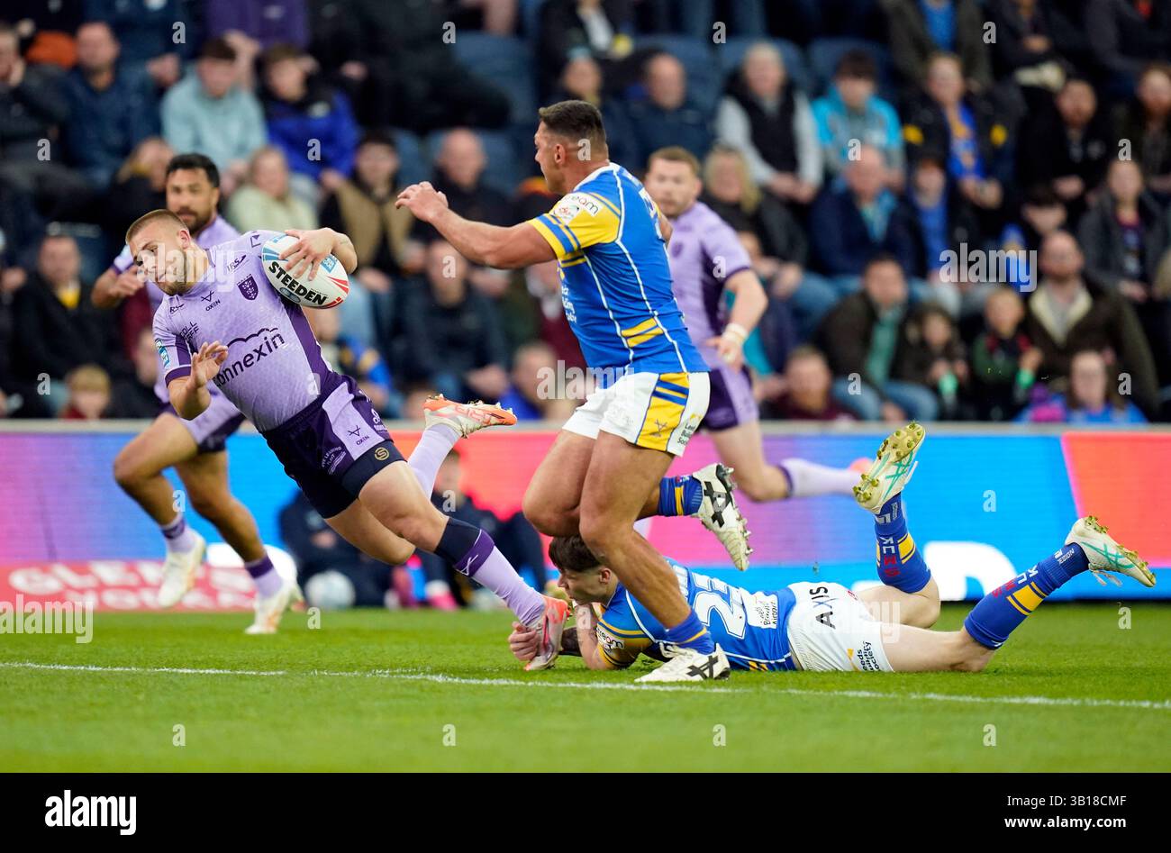Hull KR's Mikey Lewis (left) is tackled by Leeds Rhino's Riley Lumb ...