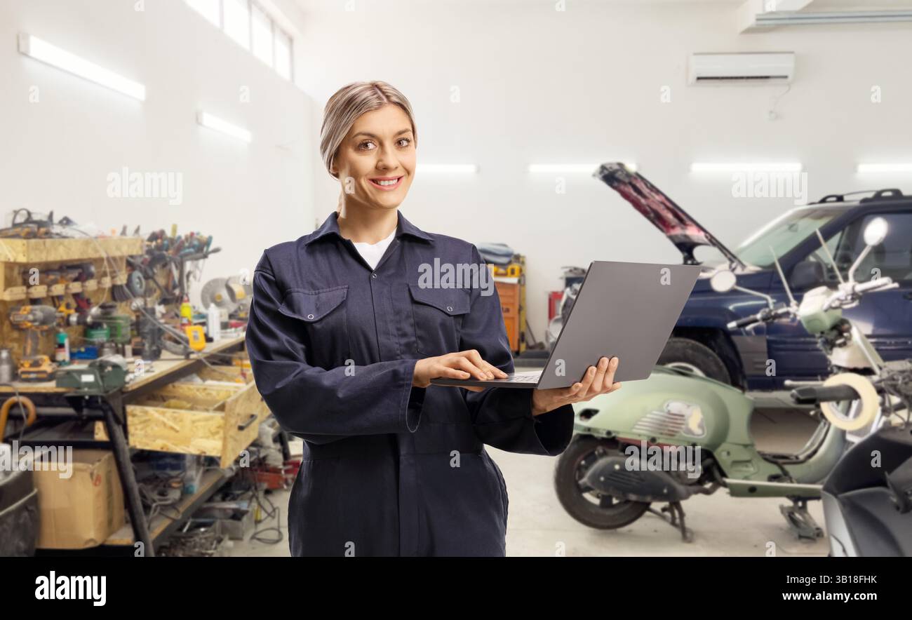 Female worker in a navy blue overall uniform with a laptop computer in ...