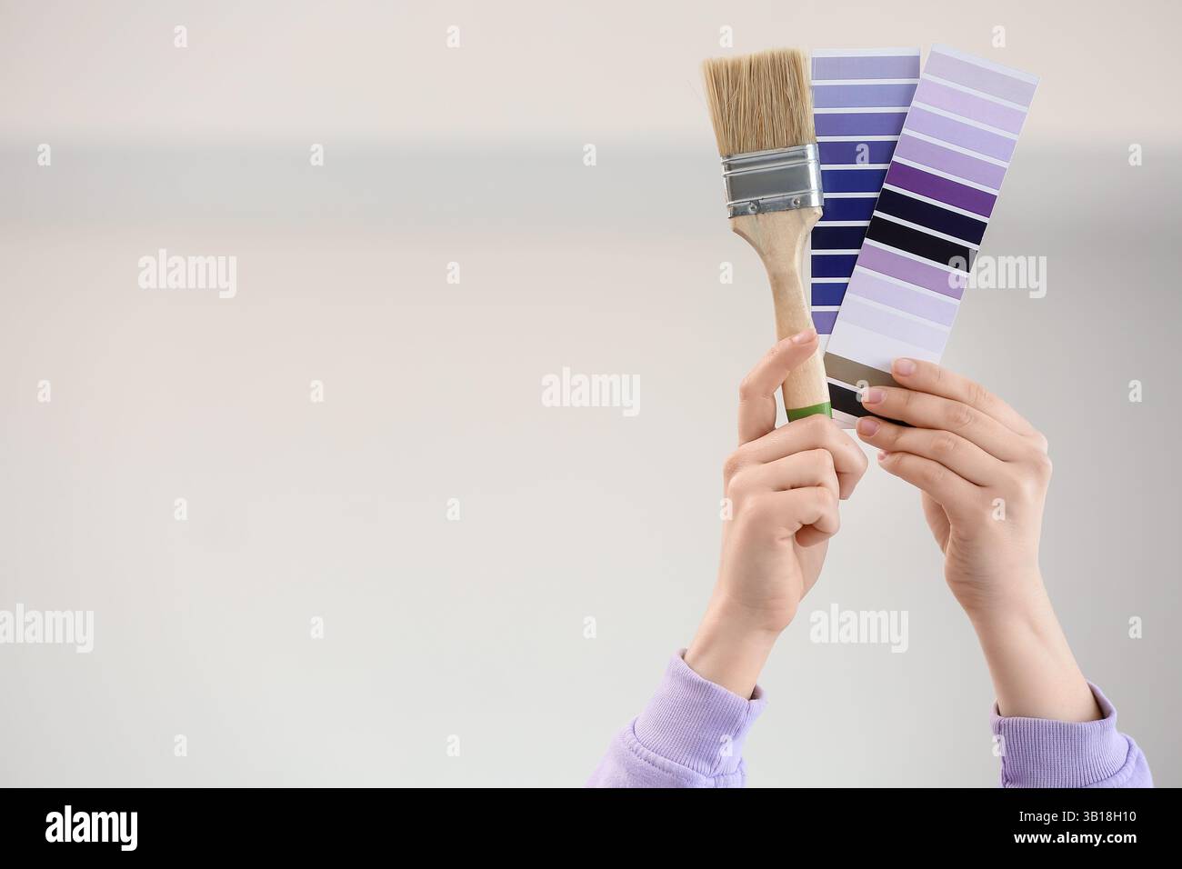 Female hands with violet paint palette swatches and brush on white ...