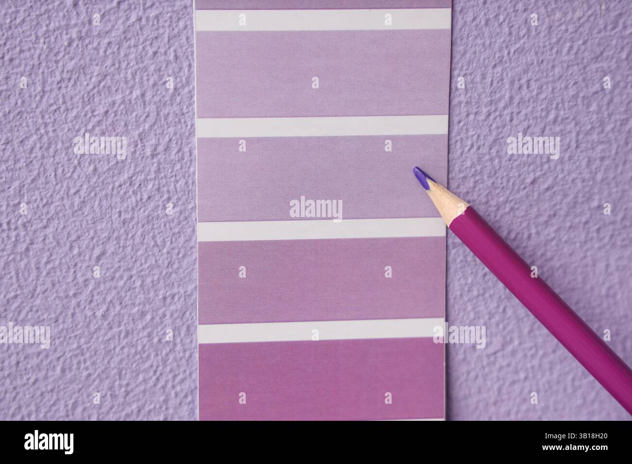 Violet paint palette swatches with pencil near lilac wall, closeup ...