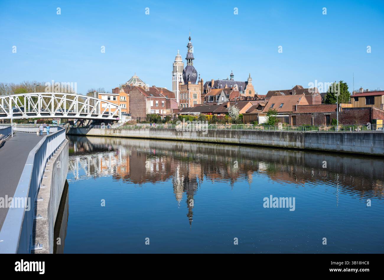 The French city of Comines Hauts De France reflecting in the river Lys ...
