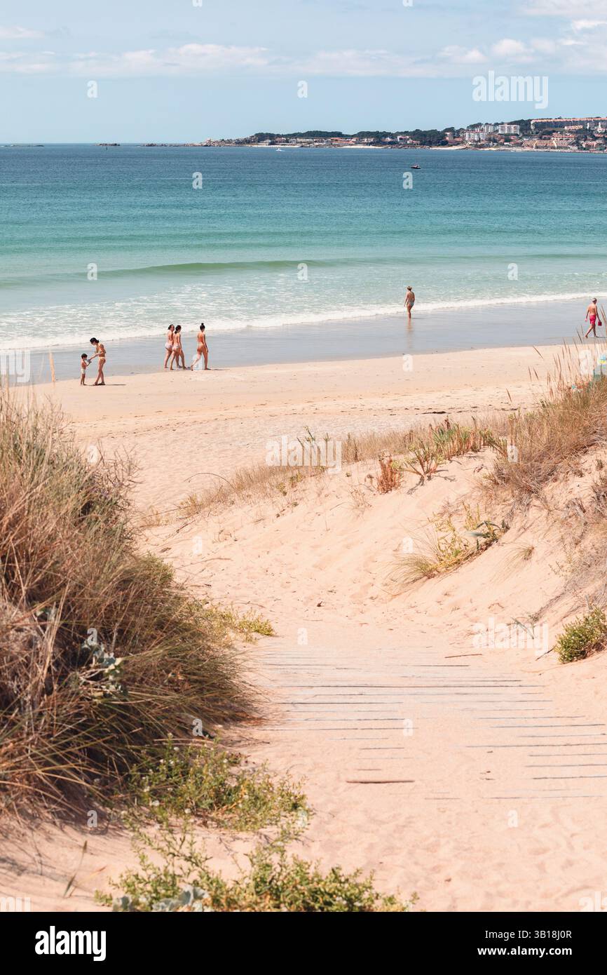Wide sandy beach with gentle waves and dunes at Praia da Lanzada ...