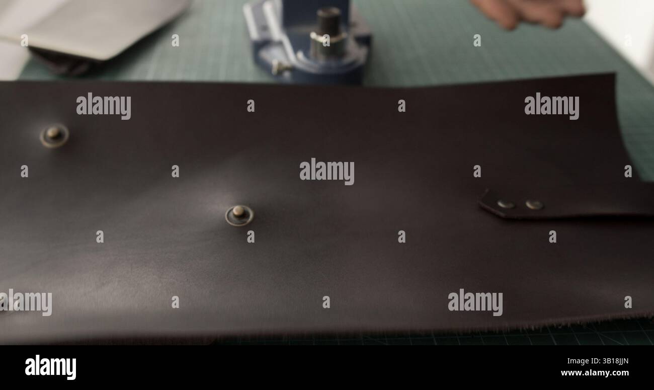Setting hardware on leather piece Stock Photo - Alamy