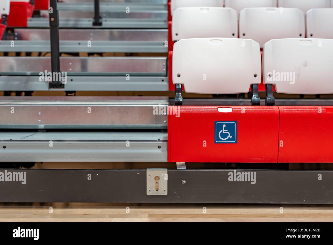Accessible symbol on the front row of red and white plastic interior ...