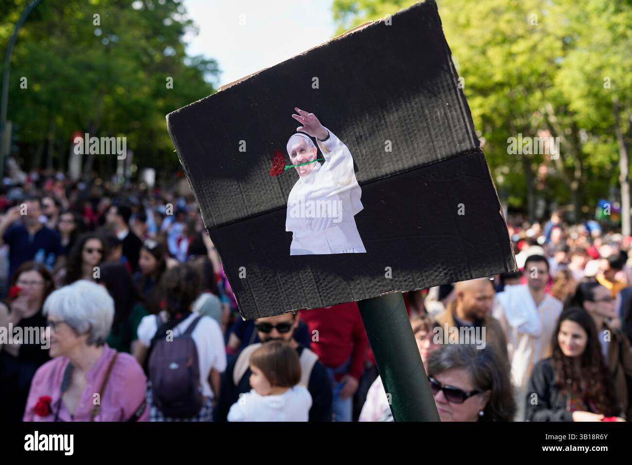 A woman carries a picture showing the late Pope Francis with a red ...