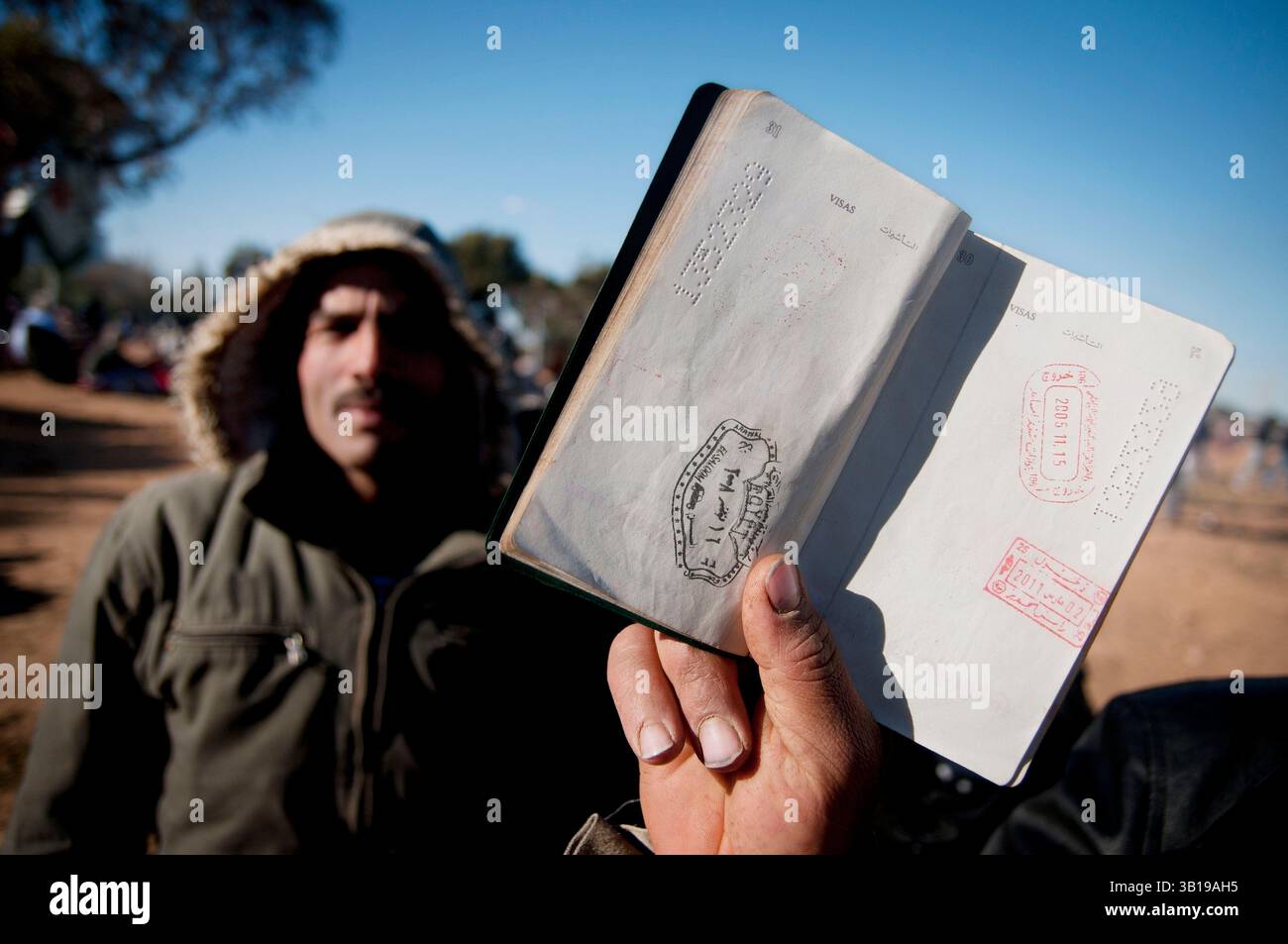 Mar. 2, 2011 - Ras Jdir, Tunisia - An Egyptian refugee holds up his ...