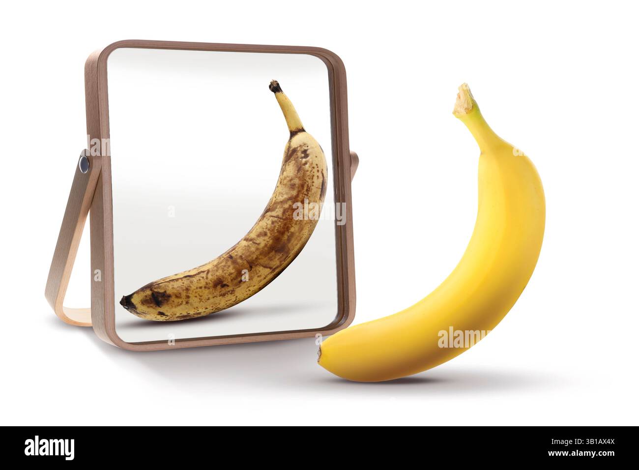 Banana reflected in mirror as one with dark spots, white background ...