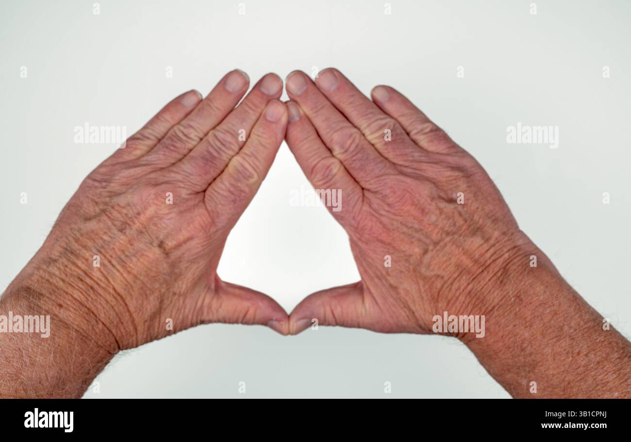 Caucasian male hands together to form triangle on white background ...