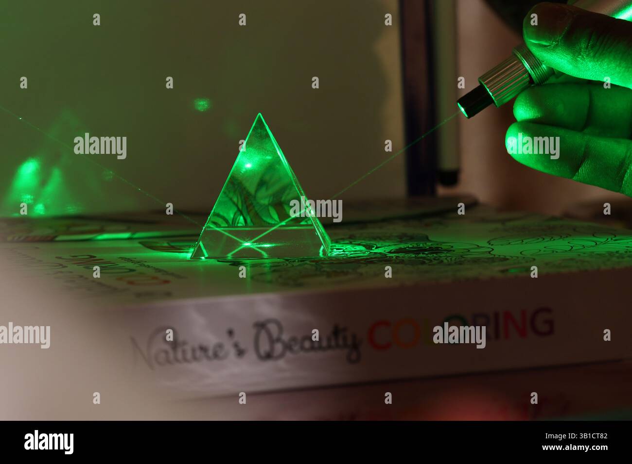 Green laser light refracting and reflecting through transparent ...