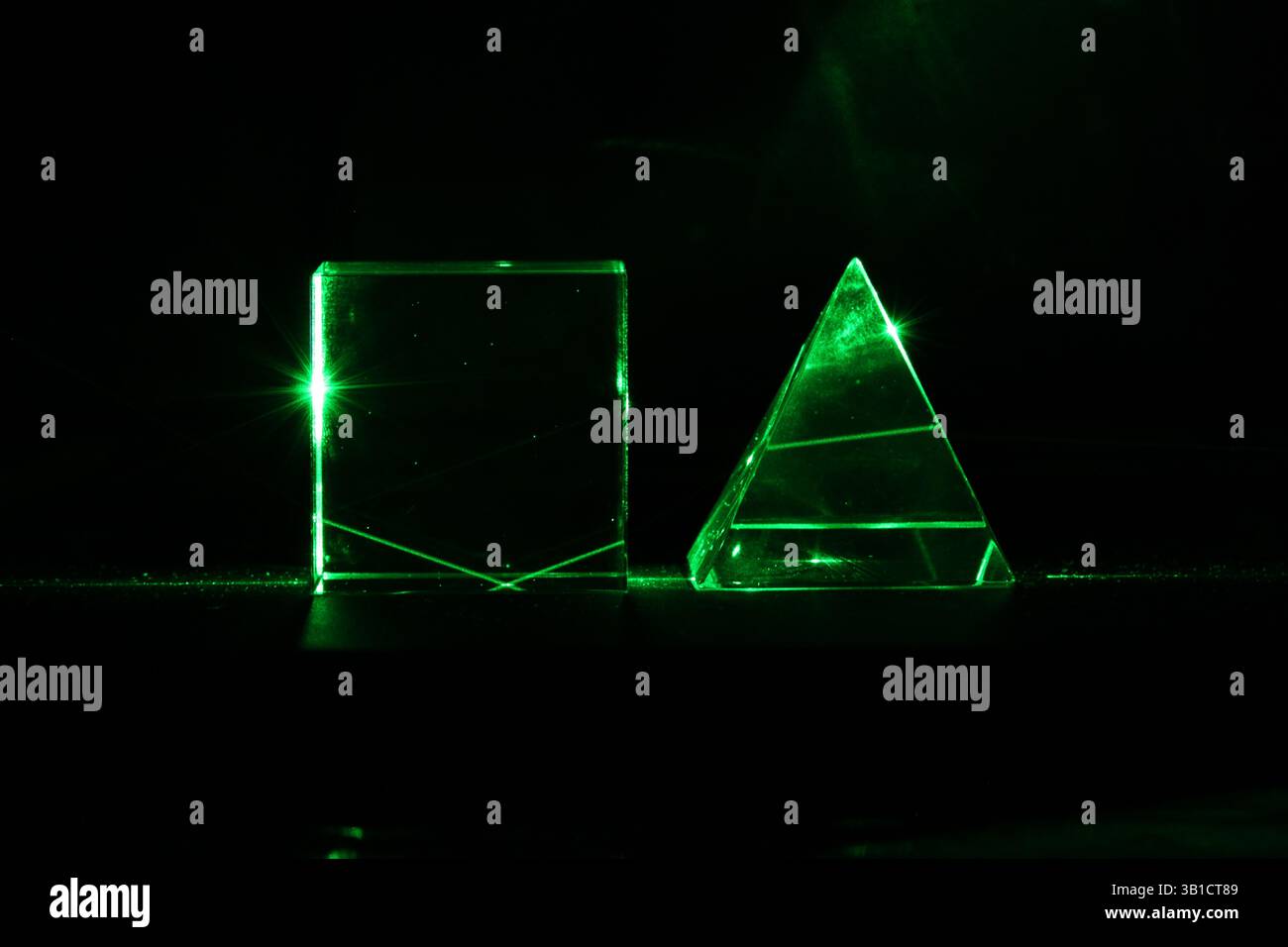 Green laser light refracting and reflecting through transparent ...