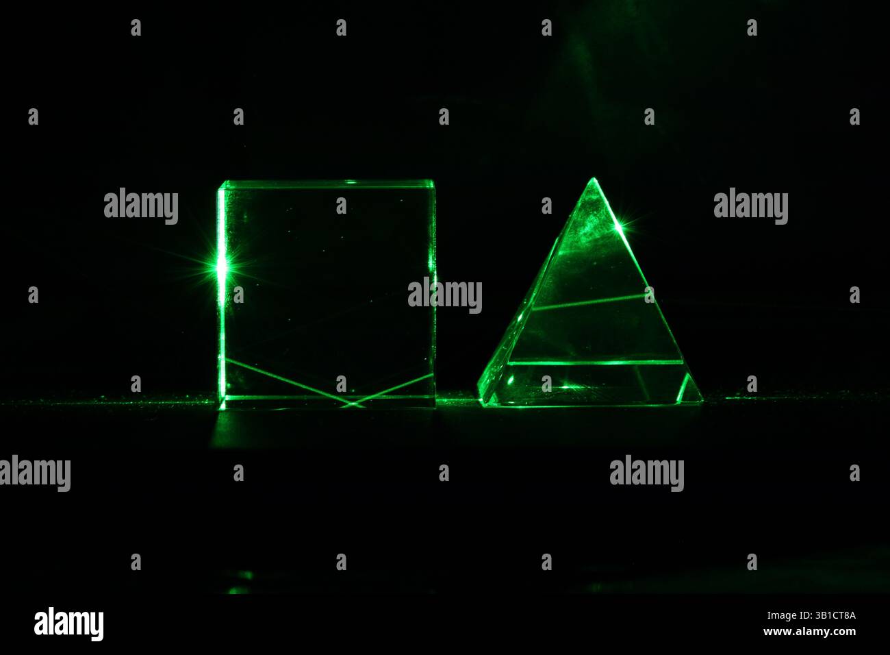 Green laser light refracting and reflecting through transparent ...