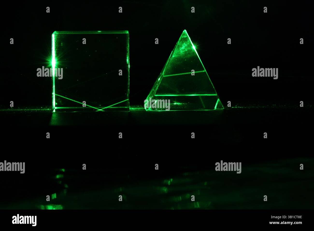 Green laser light refracting and reflecting through transparent ...