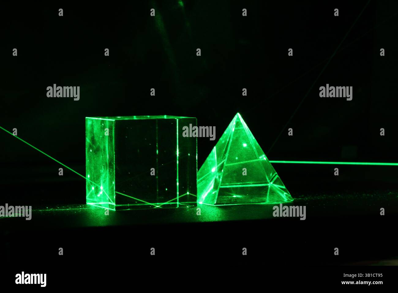 Green laser light refracting and reflecting through transparent ...