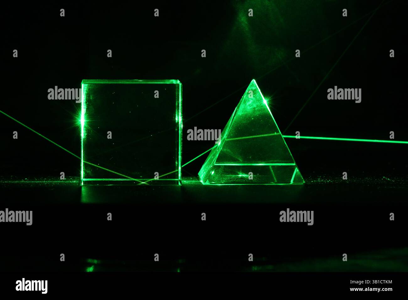 Green laser light refracting and reflecting through transparent ...