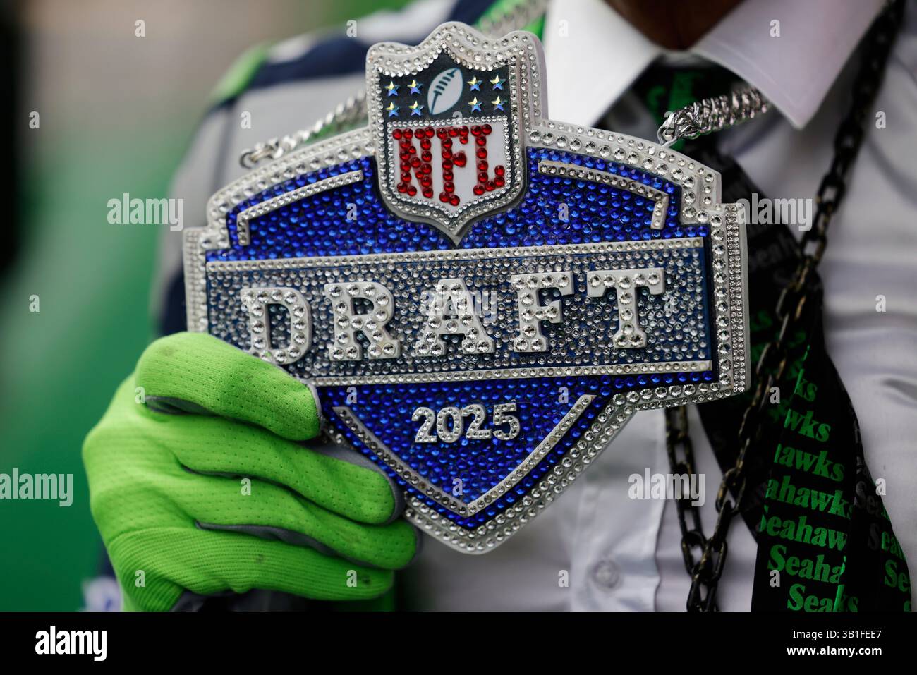 A fan holds up a necklace during the second round of the NFL football ...