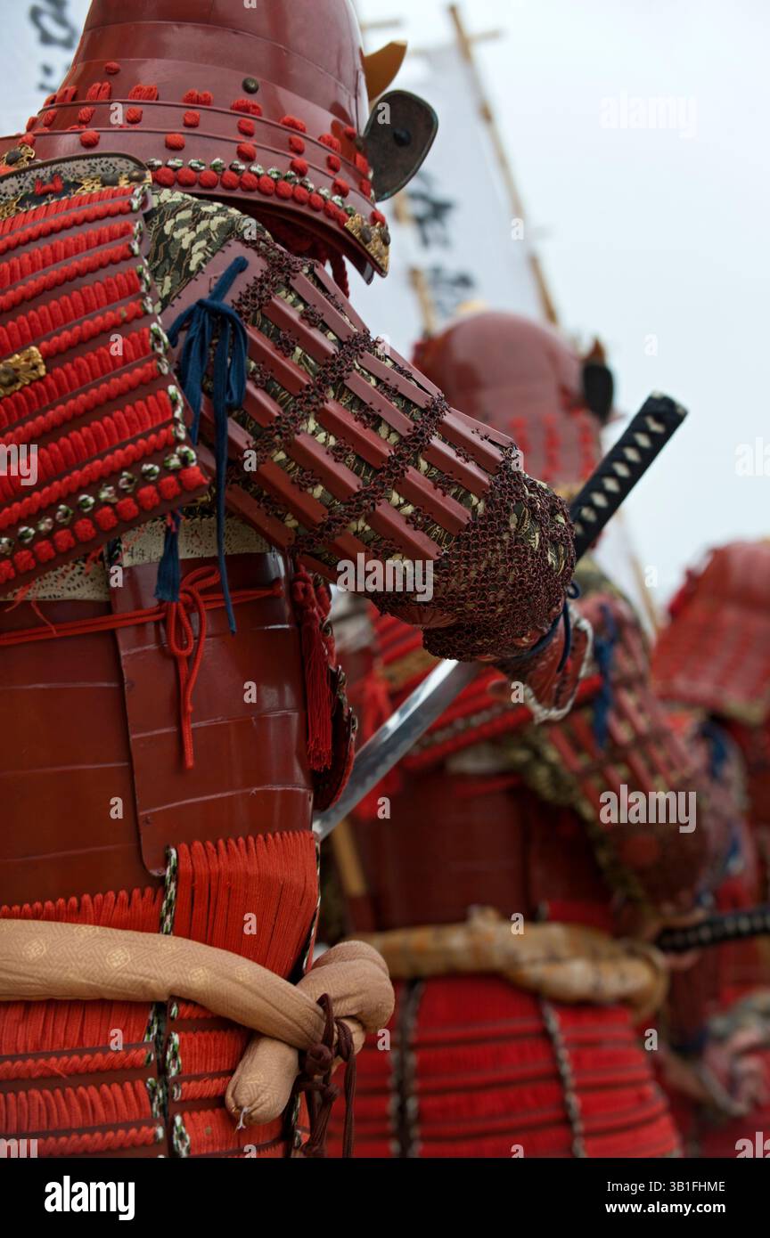 Samurai warriors in full armor costume with kabuto helmets draw their ...