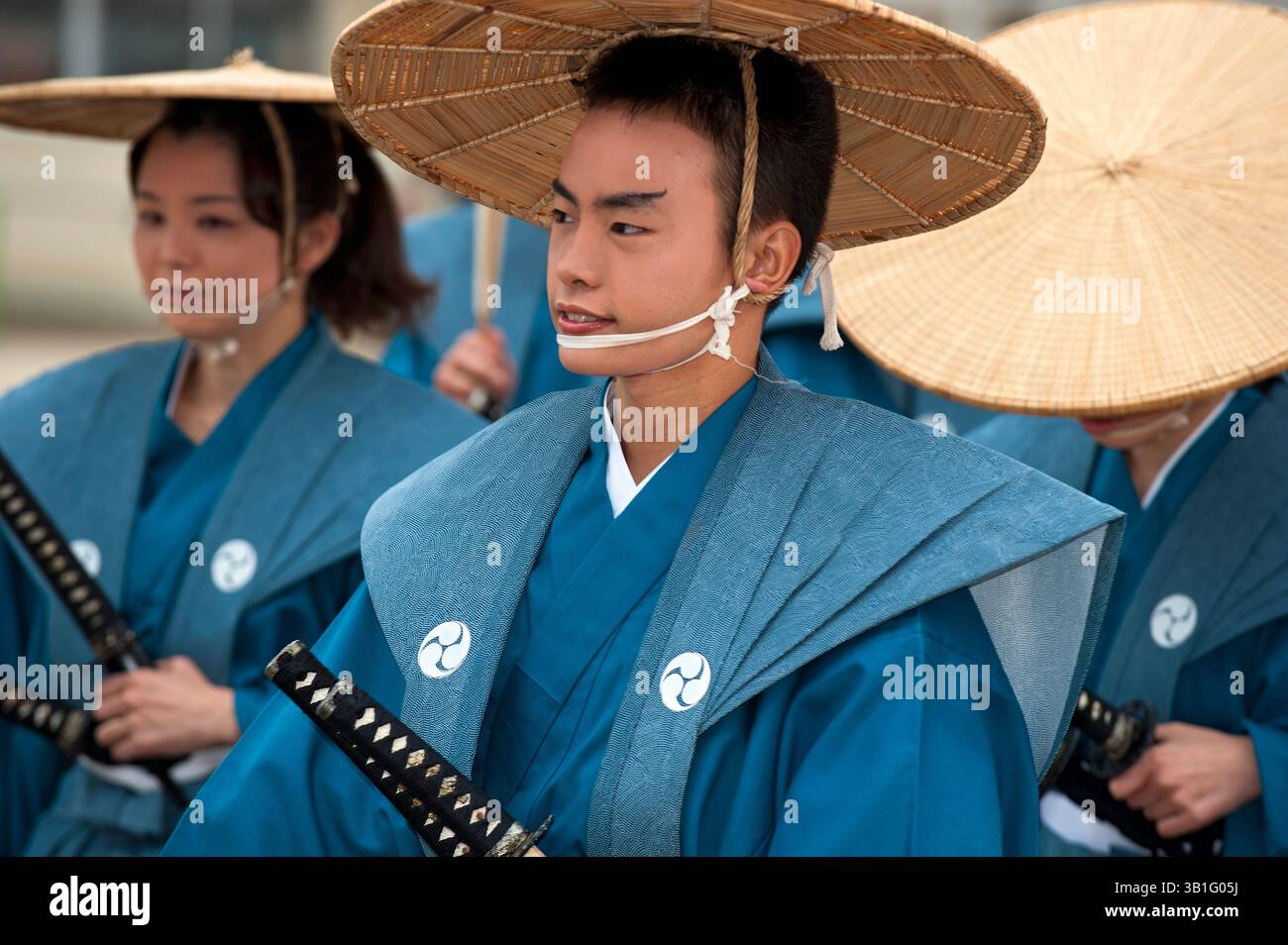 Man and woman dressed in formal samurai attire with straw hat holding a ...