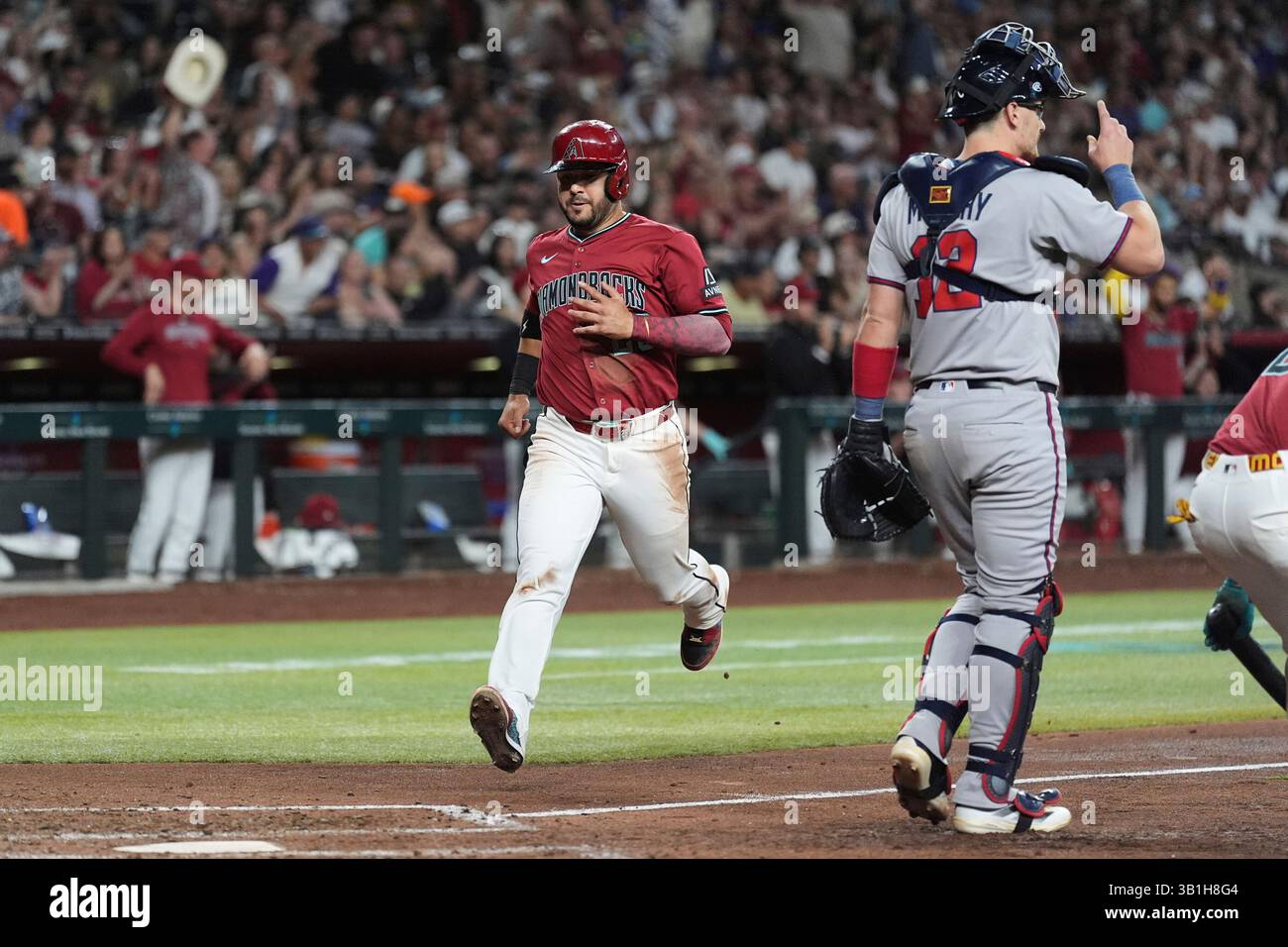Arizona Diamondbacks' Eugenio Suárez, left, scores a run as Atlanta Braves catcher Sean Murphy ...