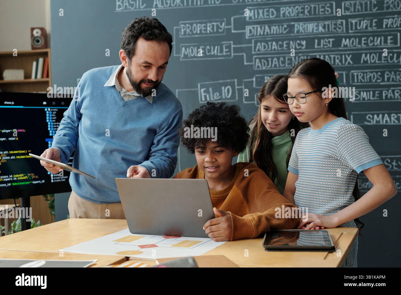Teacher Engaging Students in Computer Class With Laptops Stock Photo ...