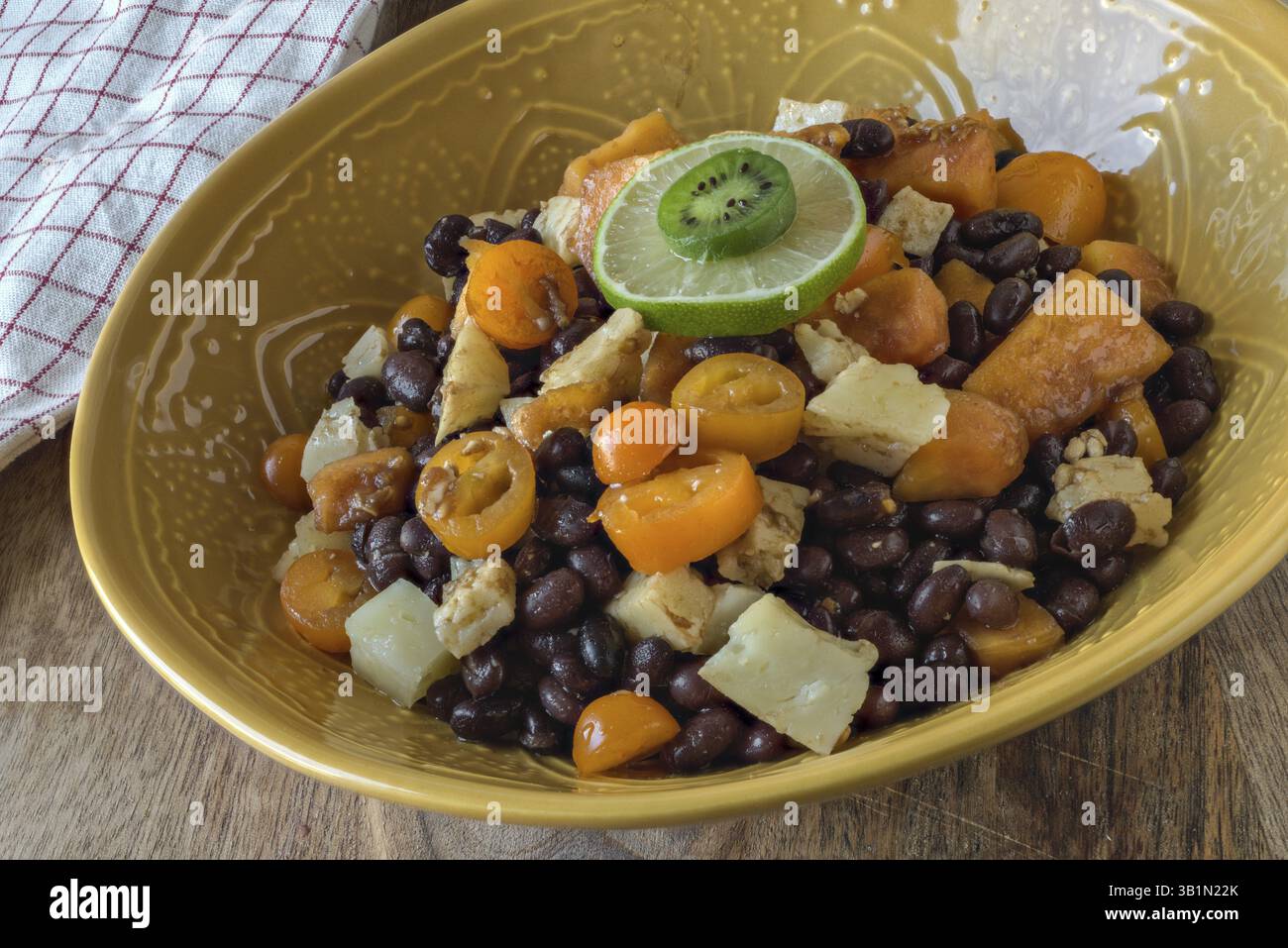 Tropical bean salad with black beans, yellow tomatoes, papaya and ...