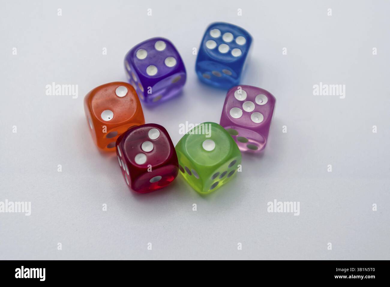 Circular arrangement of colorful translucent dice on a light background ...