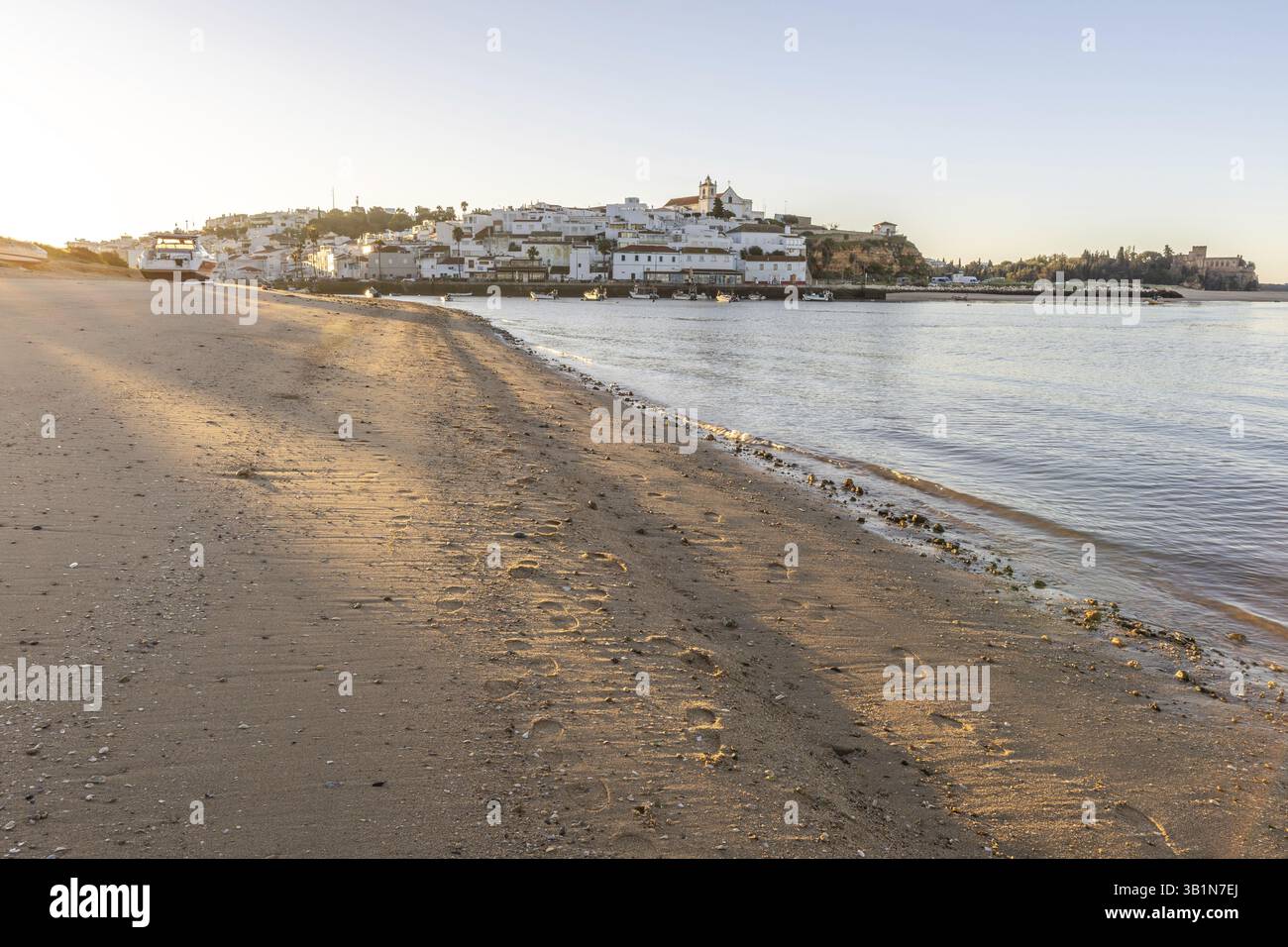 Sunrise on the Atlantic, skyline of a fishing village behind a harbour ...