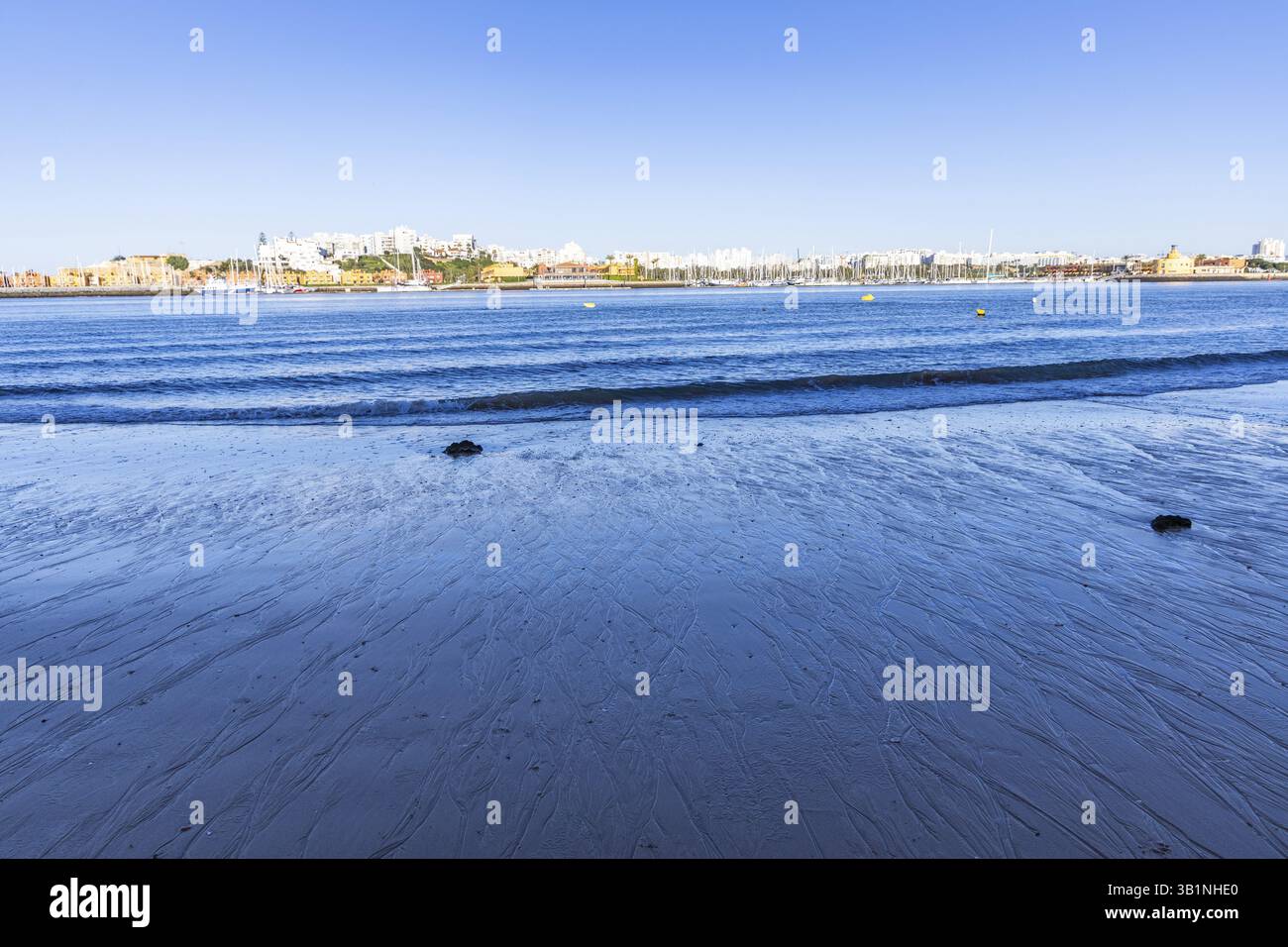 Sunrise on the Atlantic, skyline of a fishing village behind a harbour ...