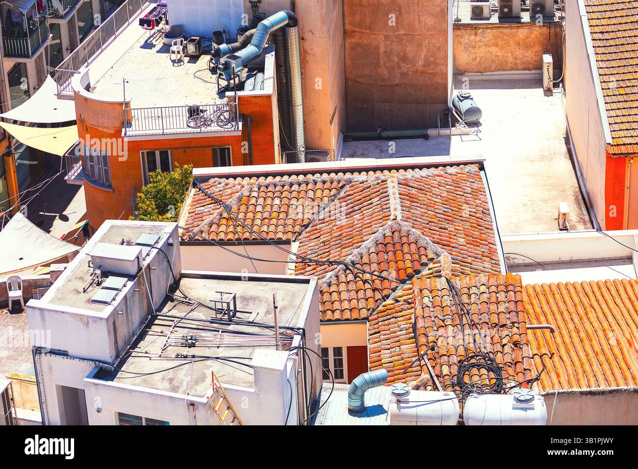 Aerial view shows a cluster of buildings with red-tiled roofs and ...
