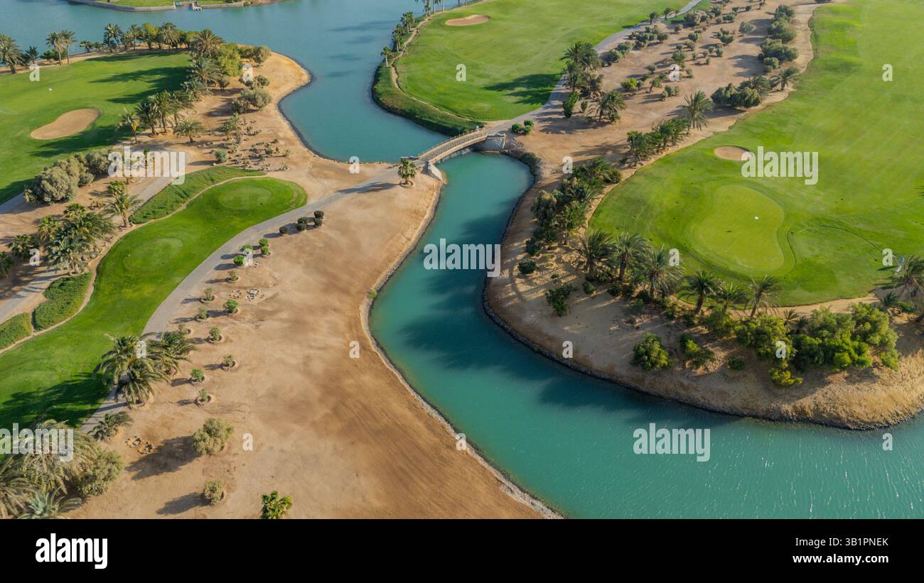 Aerial drone view showing a lush green fairway curving alongside a ...