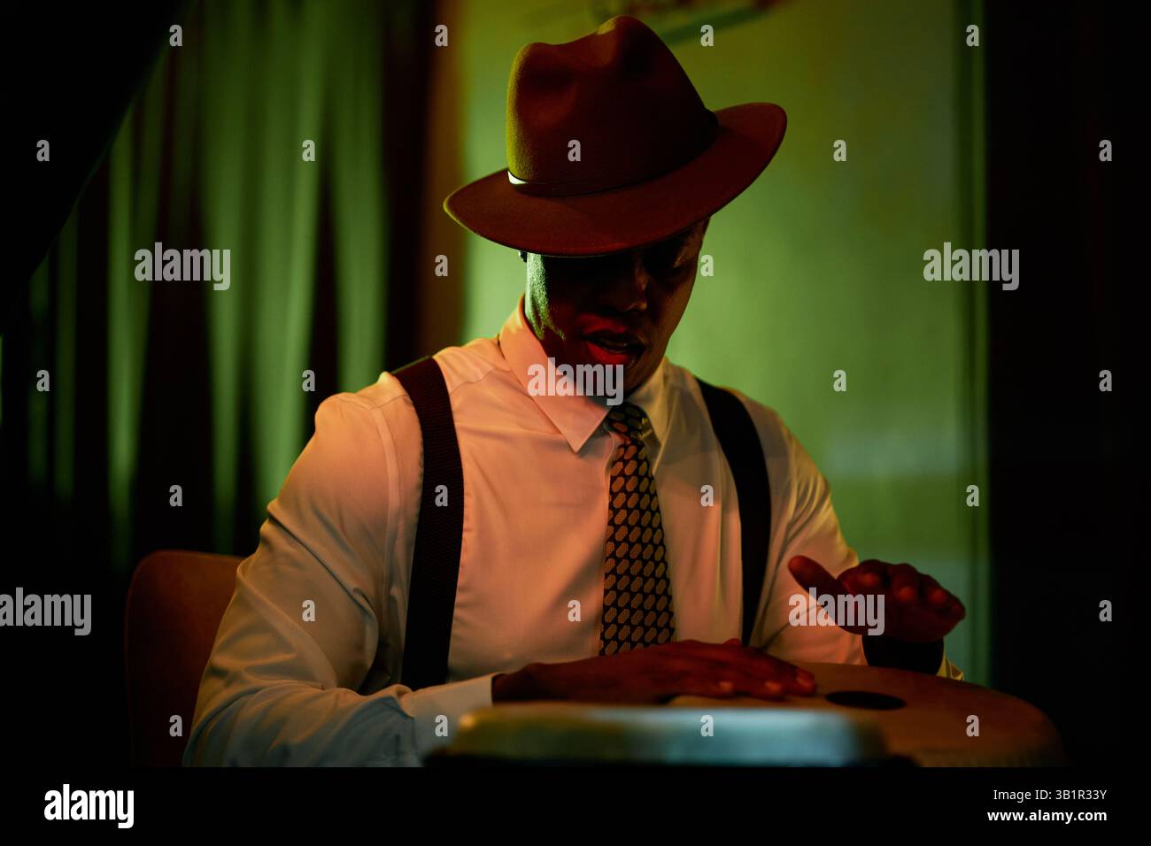 Medium shot of Black male drum musician wearing vintage hat playing ...