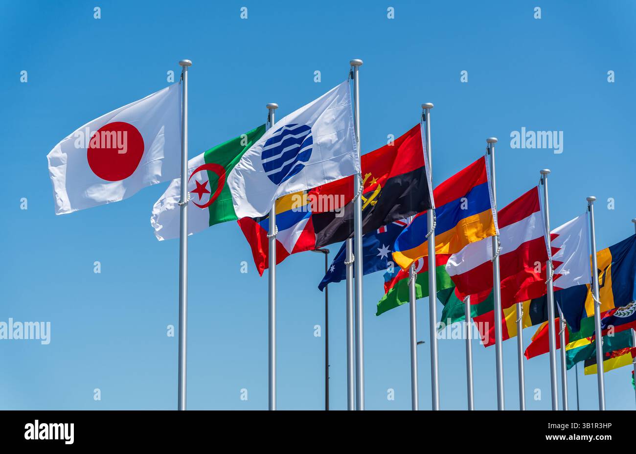 International Flags flying high against clear sky at the Entrance of ...