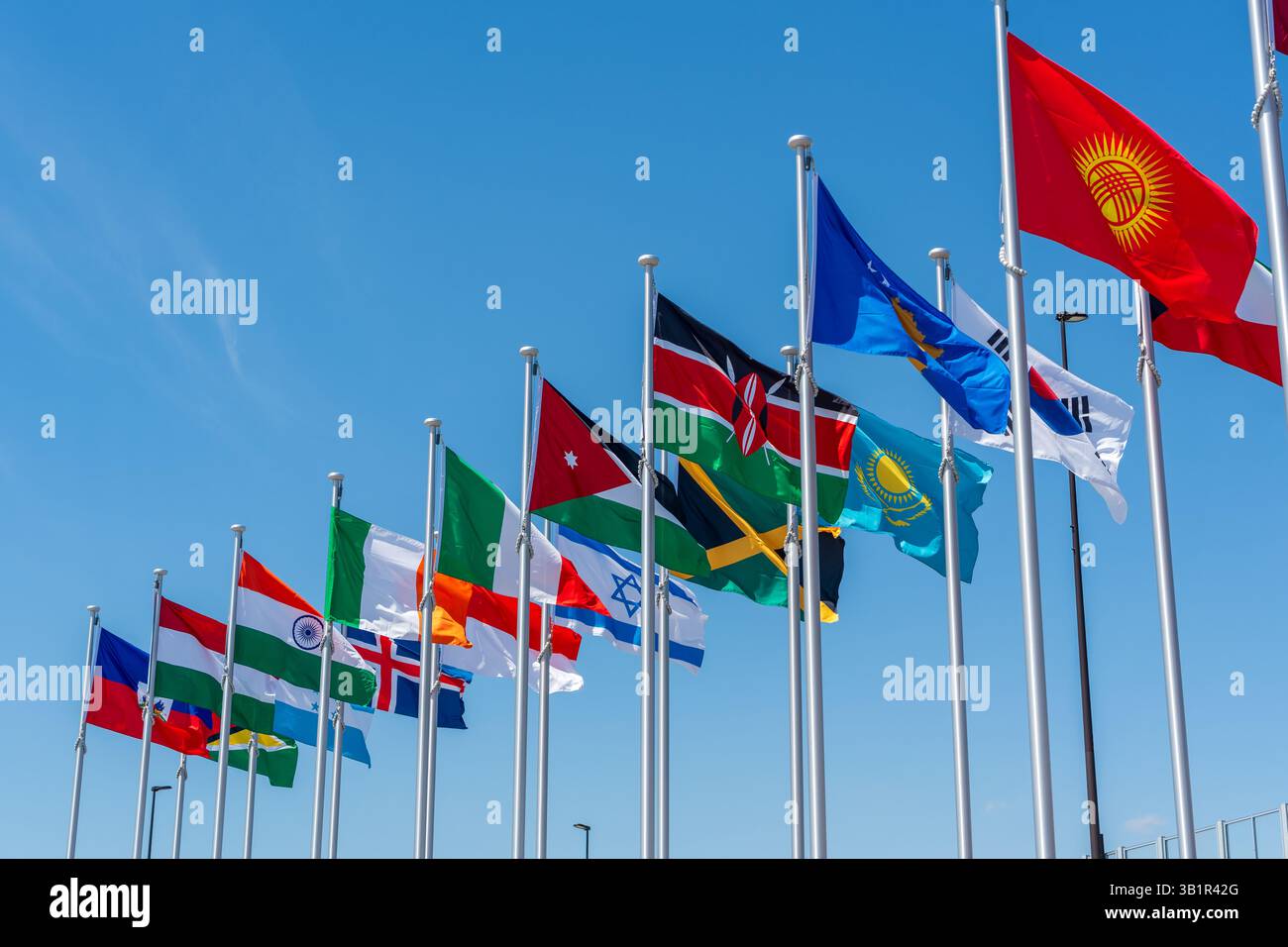 International Flags flying high against clear sky at the Entrance of ...