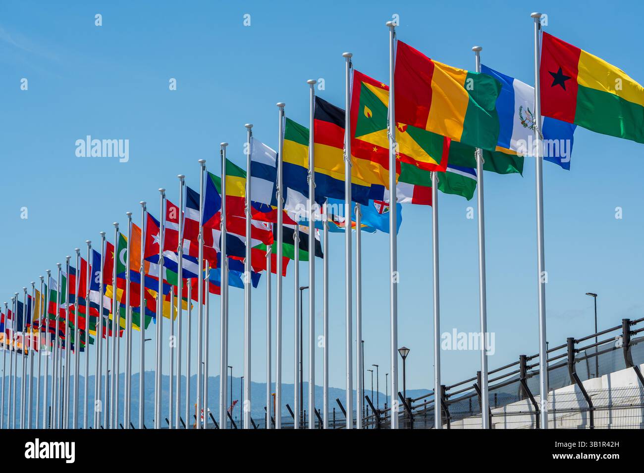 International Flags flying high against clear sky at the Entrance of ...