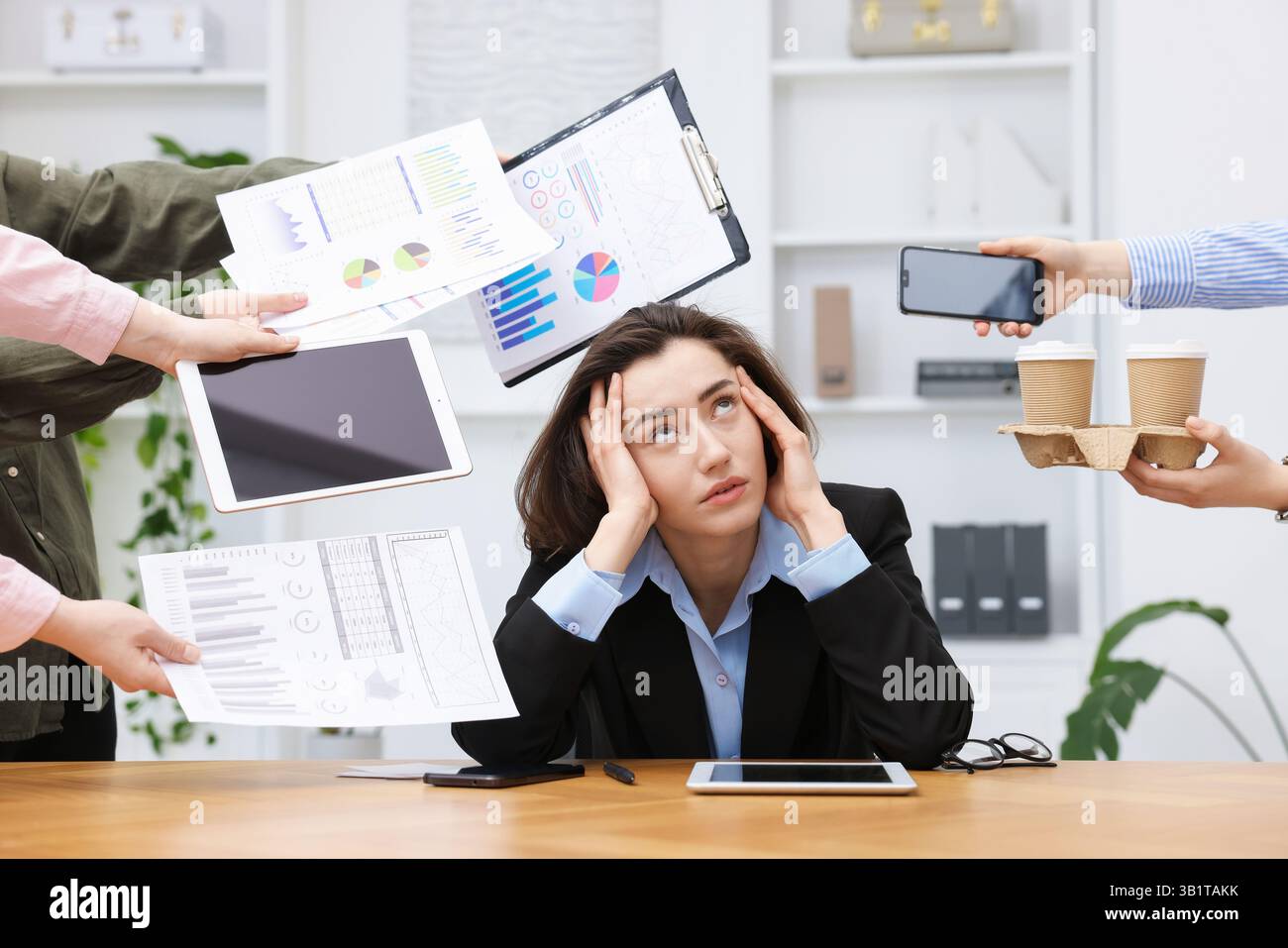 Woman overwhelmed by different requests from colleagues at desk in ...