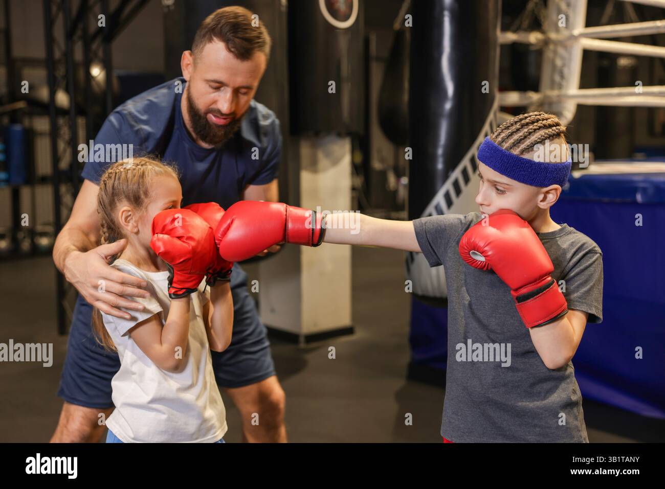 Boxing coach training children in sport center Stock Photo - Alamy