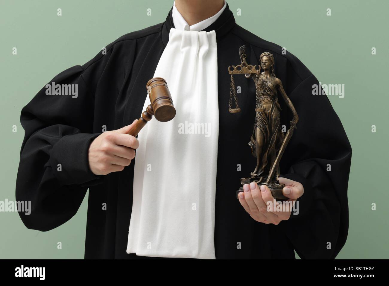 Judge with mallet and figure of Lady Justice on light green background ...