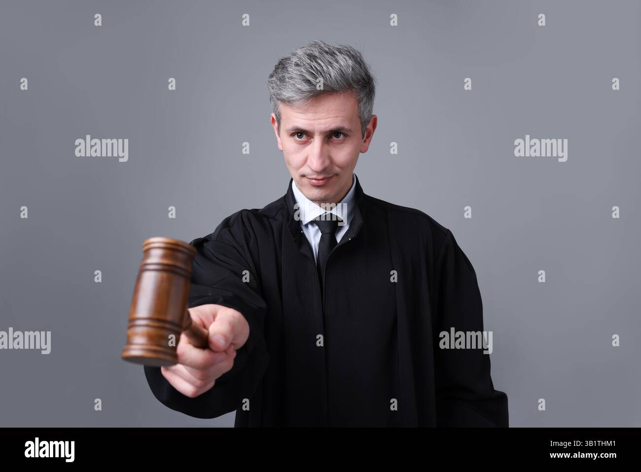 Portrait of judge with mallet on grey background Stock Photo - Alamy