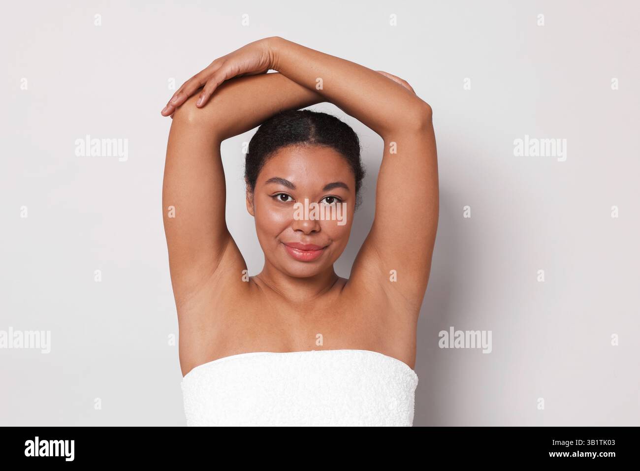 Woman showing hairless armpits after epilation procedure on light grey ...