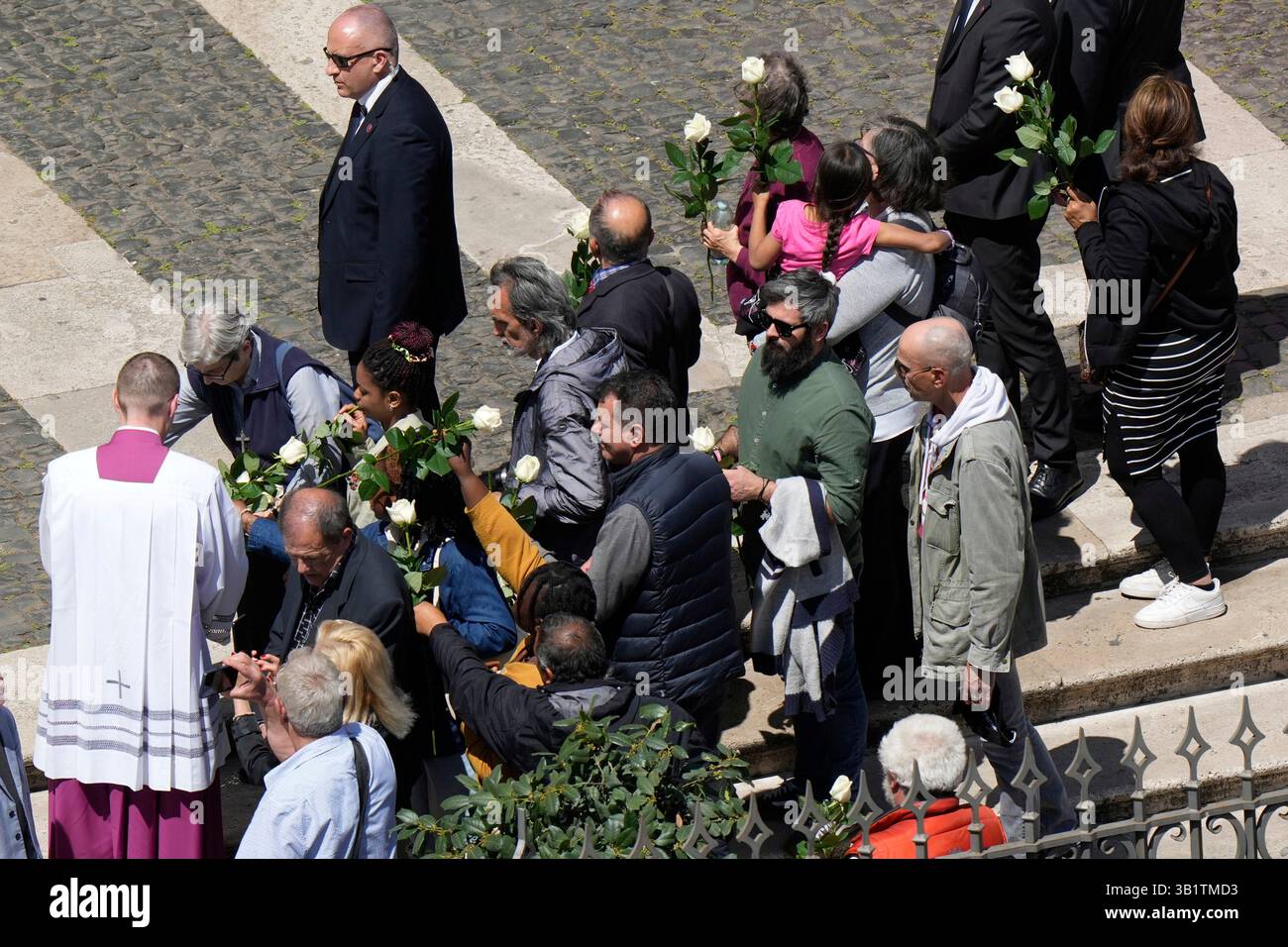 Faithful holding white roses wait for the burial ceremony of Pope ...