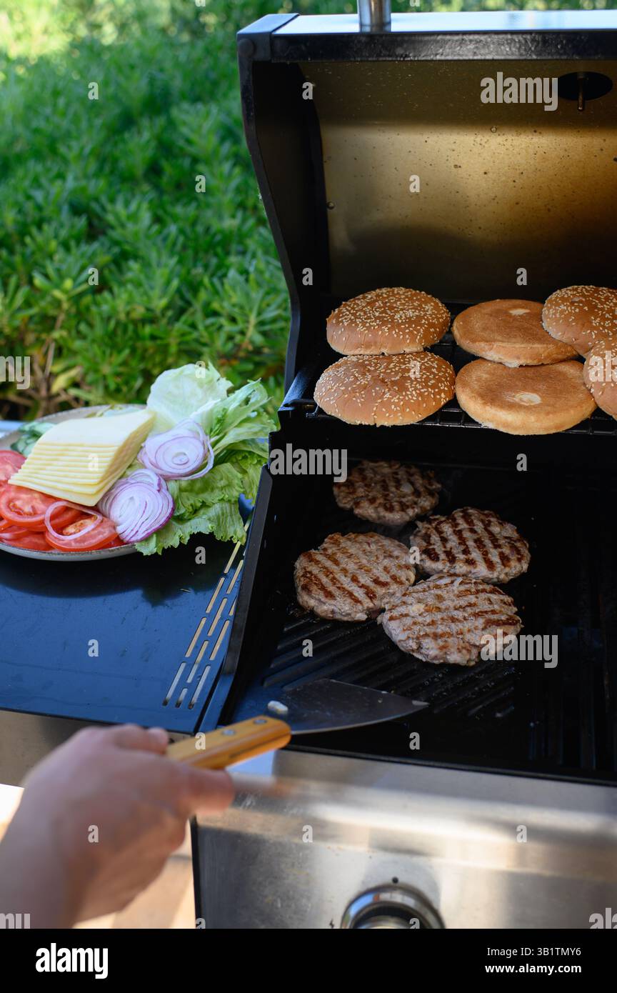 A man is standing near the grill on a terrace, grilling meat Stock ...