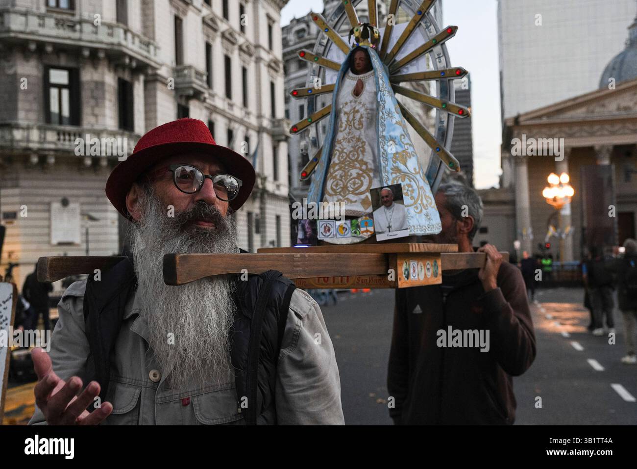 Several people carry an image with the Pope's face for the funeral of ...