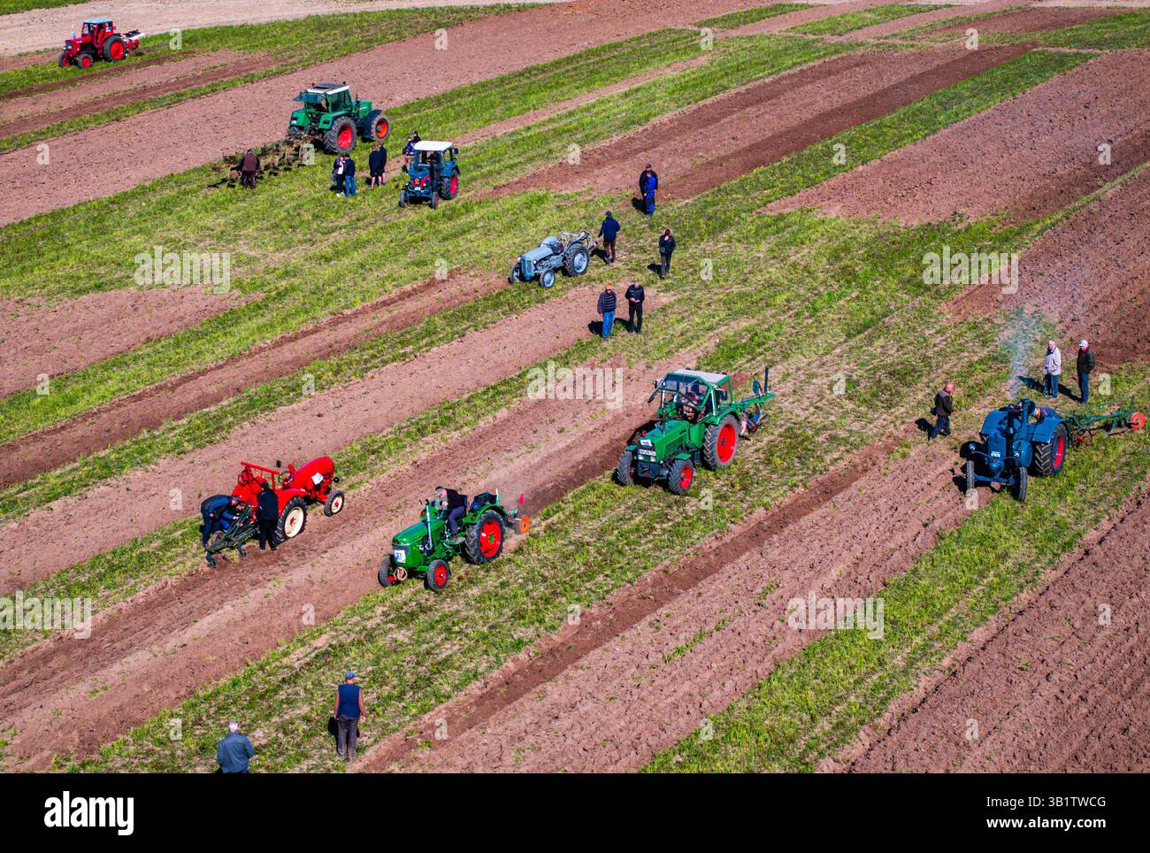 Goddin, Germany. 26th Apr, 2025. Historic tractors drive across a field ...