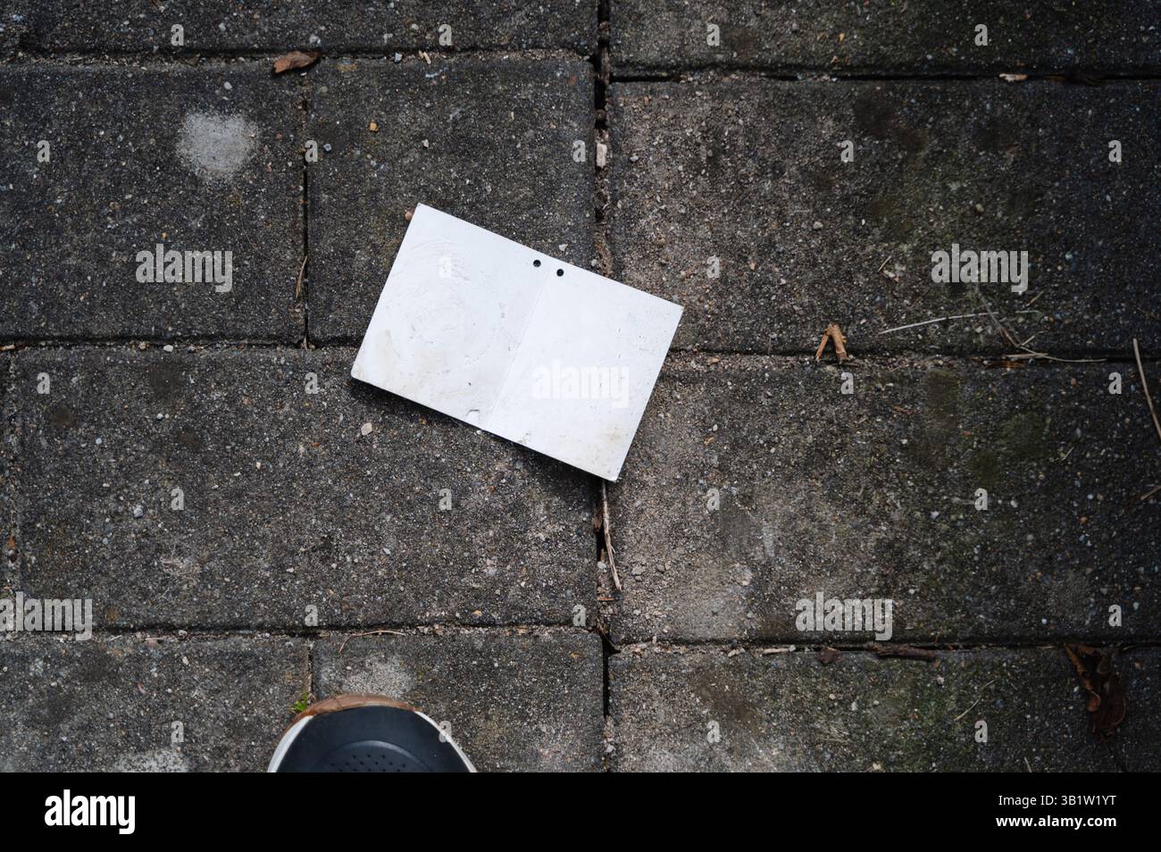 A plain white piece of paper is currently laying flat on the ground ...