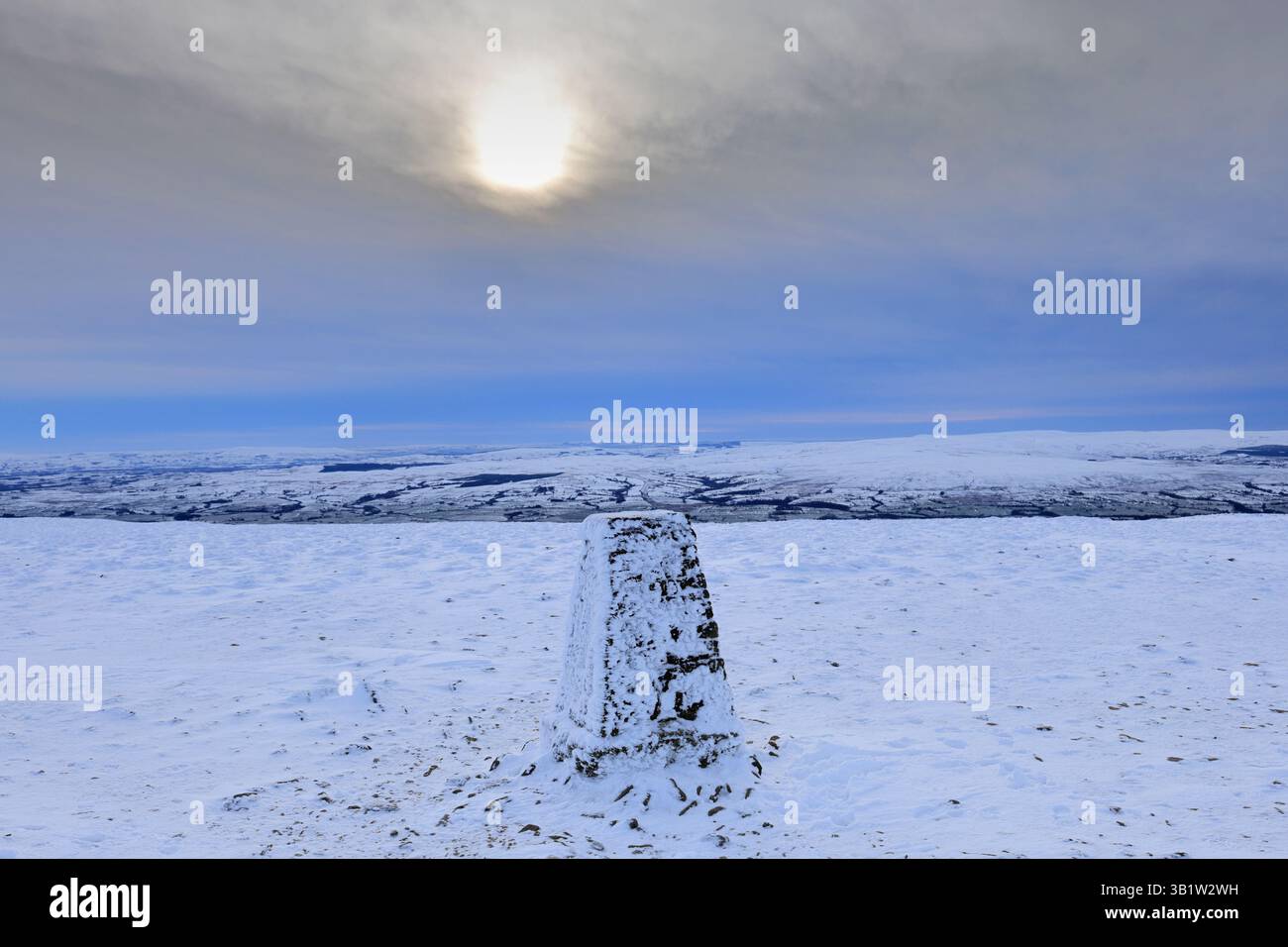 Winter snowy view of the OS Trig Point on the summit of Ingleborough ...