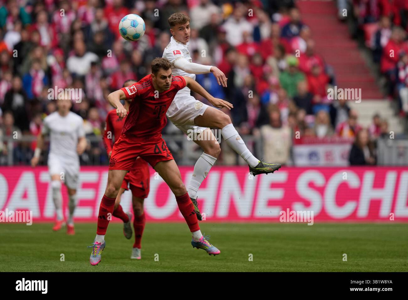 Bayern's Josip Stanisic, left, duels for the ball with Mainz's Nikolas ...