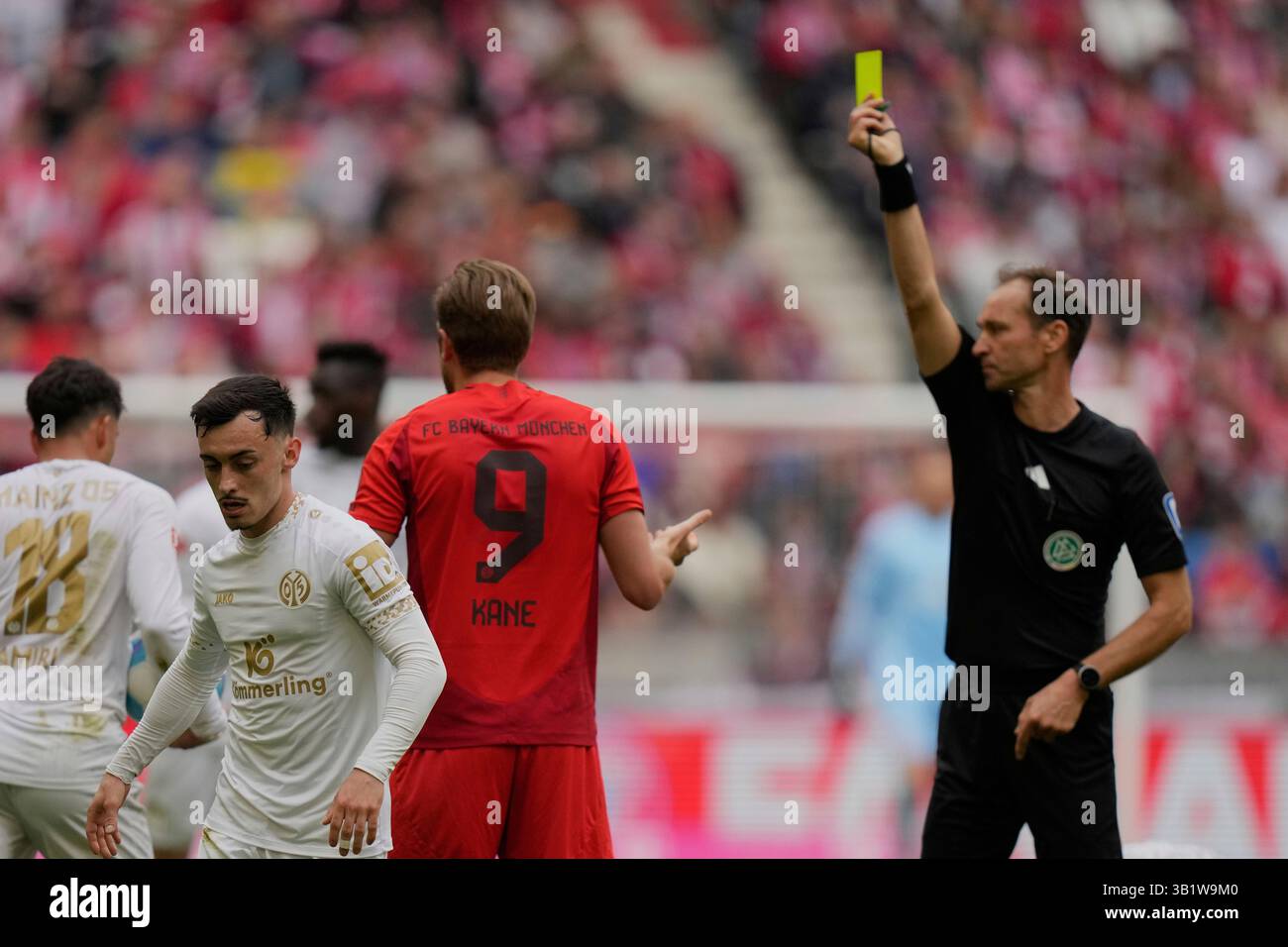 Referee Bastian Dankert, right, shows a yellow card to Bayern's Harry ...