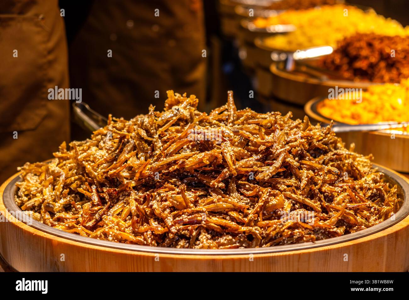 Chinese street food. Deep fried crispy tiny fish, sweet and spicy dried ...